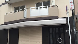 Um edifício moderno com fachada curva, grandes portões de garagem e entrada preta com design circular.
