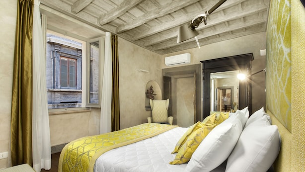 Quarto com cama, janela, cadeira e ar-condicionado.
