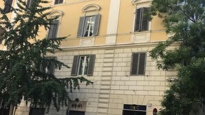 Um edifício amarelo de vários andares com fachada comercial no andar térreo.