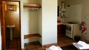 Uma cozinha pequena com fogão, pia e um varal.