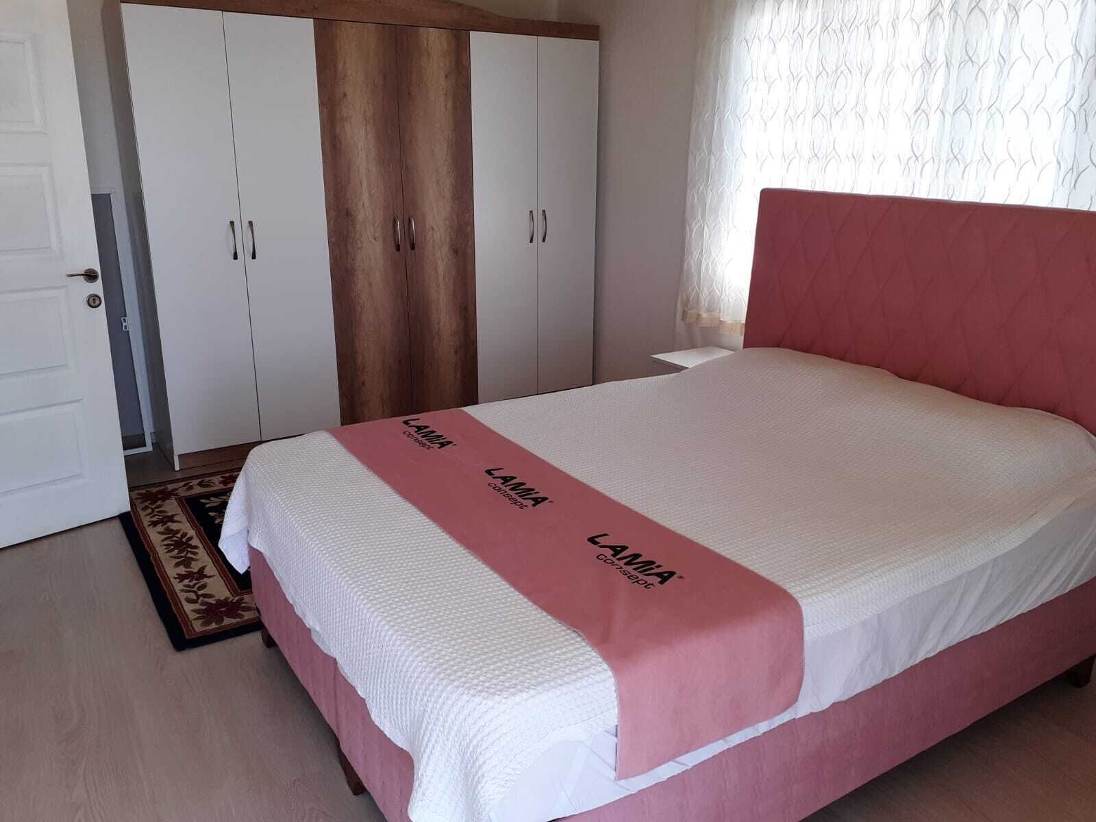 Quarto com uma cama, um guarda-roupa e uma porta.