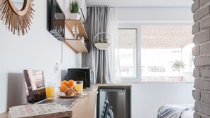 Cozinha moderna com área de refeições, uma pequena geladeira e janela com vista para o exterior.