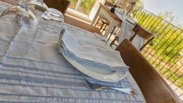 Mesa posta com pratos, copos e garfo sobre toalha xadrez.