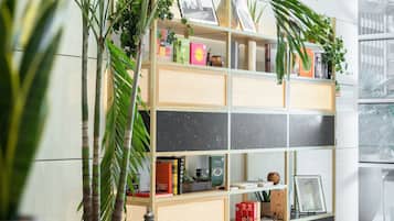 Uma estante com livros, objetos decorativos e plantas.
