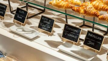 Vitrine de pastelaria com diversos doces e um bolo de chocolate.