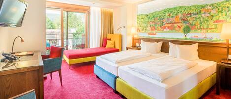 Quarto de hotel com duas camas, uma escrivaninha, uma cadeira, uma televisão e um quadro de uma cidade na parede.