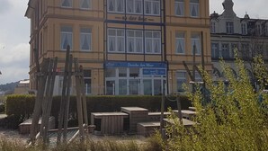 Um hotel de vários andares com uma placa indicando 'Domaine Am Meer' no andar térreo.