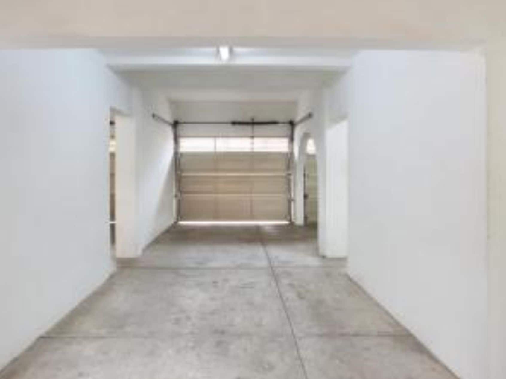 Um corredor com uma porta de garagem fechada no fim.