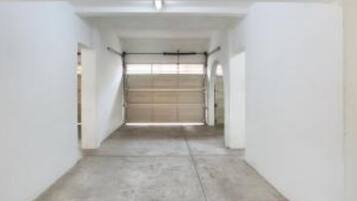 Um corredor com uma porta de garagem fechada no fim.