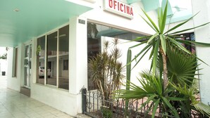 Um edifício com uma placa que diz "OFICINA" e o número "320" na porta.
