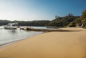 Na praia, espreguiçadeiras, guarda-sóis, toalhas de praia 