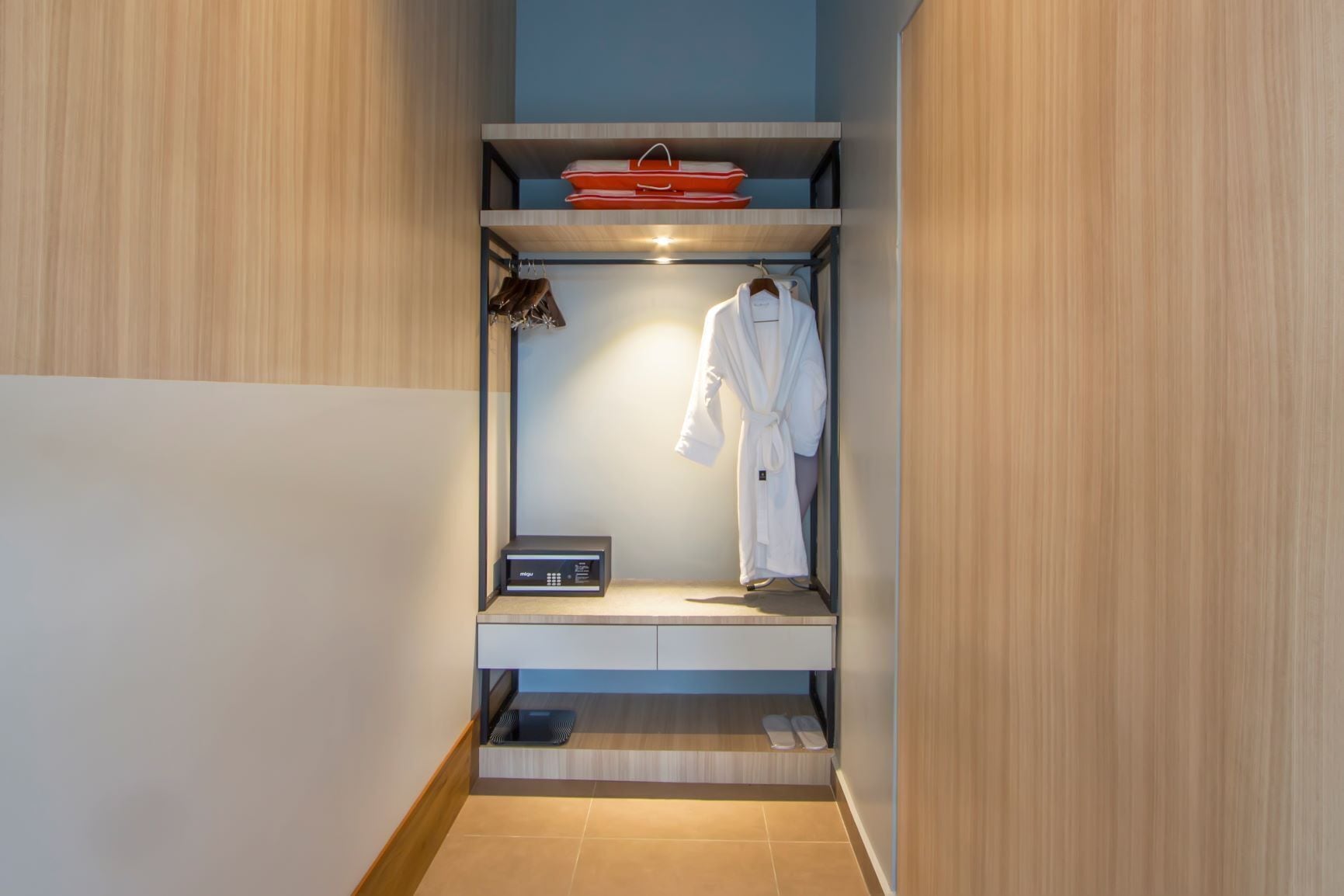 Um closet amplo com aquecedor embutido, prateleiras com roupas dobradas e um cabideiro.
