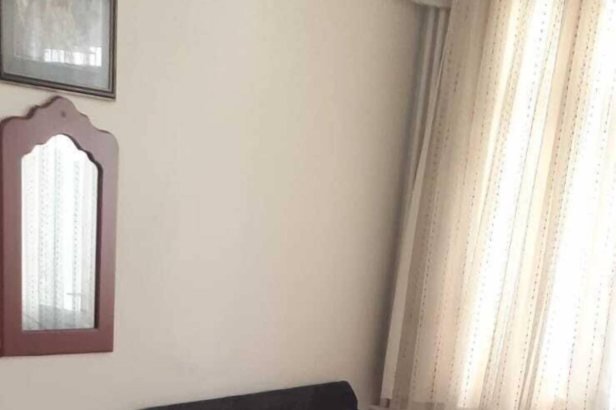 Quarto de hotel com duas camas, mesa de cabeceira com telefone e um quadro pendurado na parede.