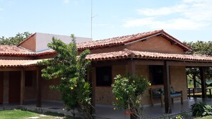 Um edifício com uma placa indicando 'POUSADA VILA DAS MANGABIRAS'.