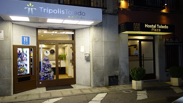 Entrada de hotel com placas indicando 'Trípolis Toledo Hotel' e 'Hostal Toledo Plaza'.