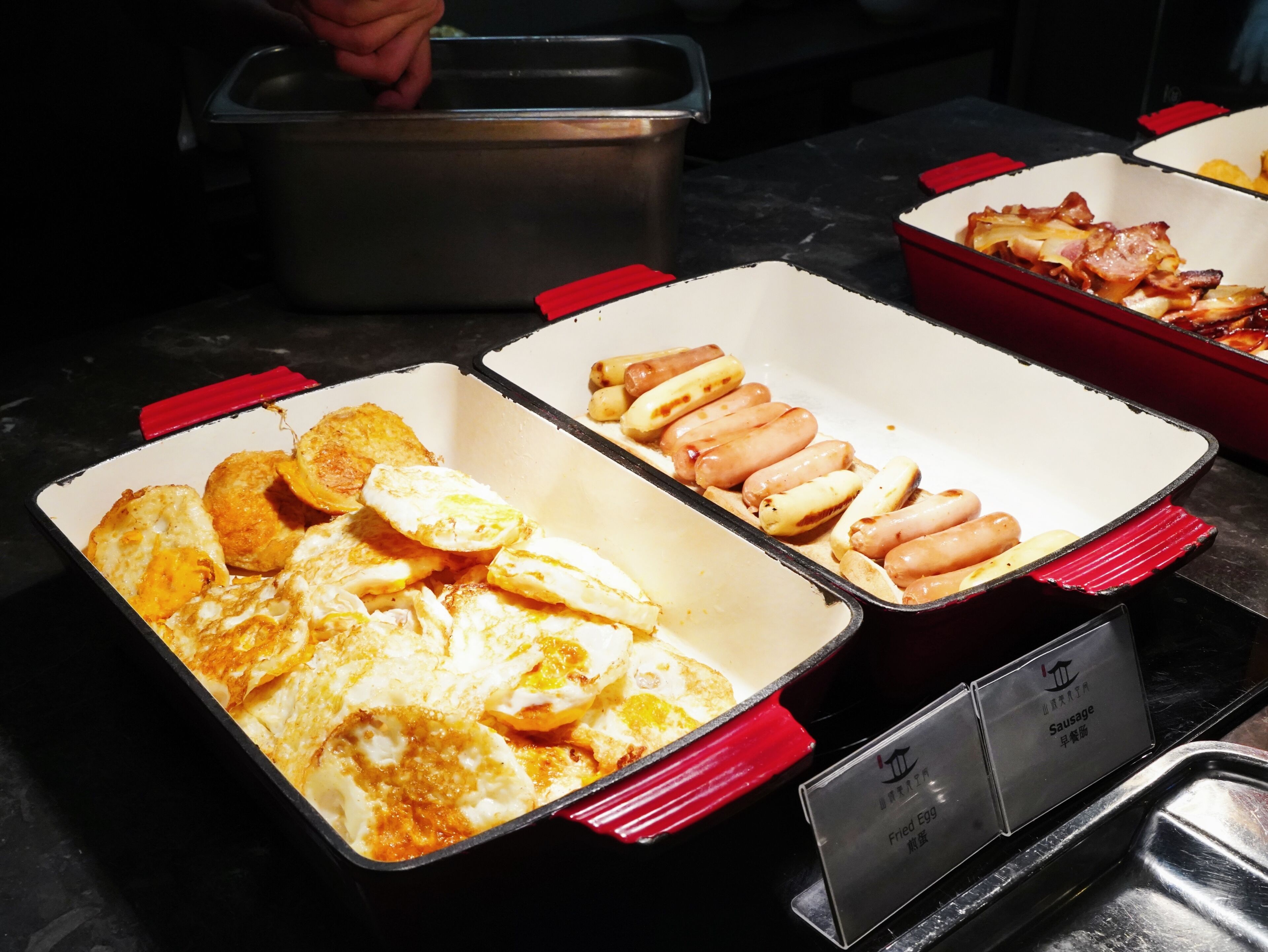 Buffet com ovos fritos e salsichas.