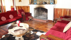 Uma sala de estar aconchegante com sofás vermelhos, uma mesa de centro de madeira e uma lareira.