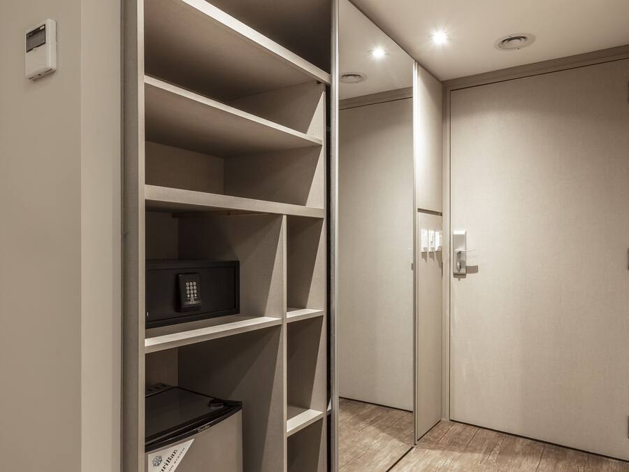 Um closet amplo com prateleiras embutidas e um cofre.