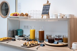 Um buffet de café da manhã com diversos alimentos e bebidas.