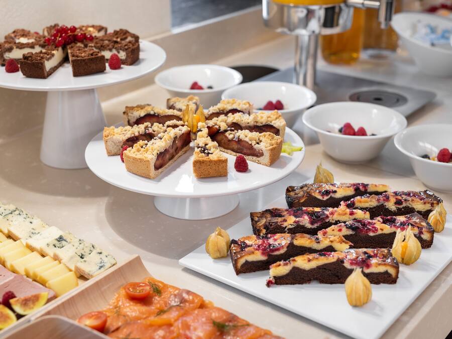 Um buffet com diversos doces e queijos.