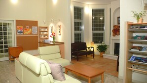 Uma sala de estar com sofá, mesa de madeira, lareira e estante de livros.