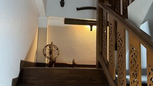 Uma escadaria de madeira com grades elaboradas que leva a um patamar.