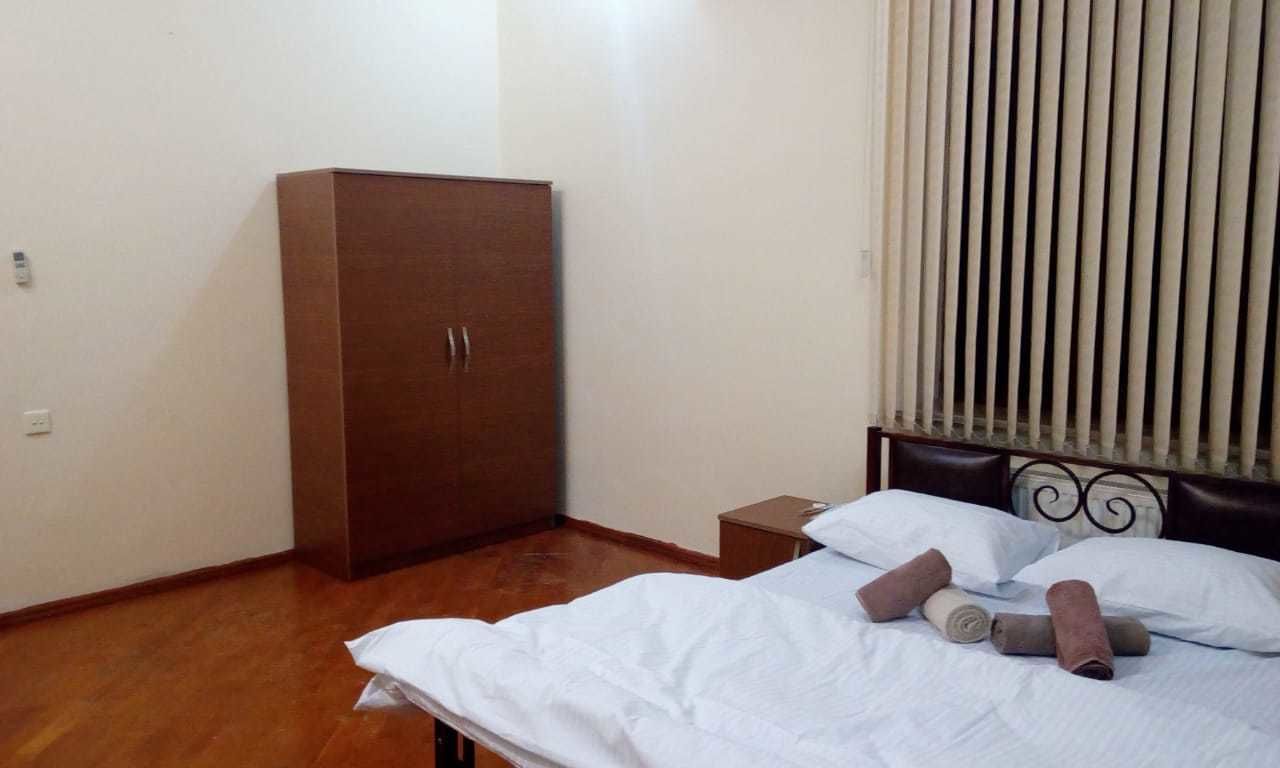 Quarto com cama, guarda-roupa e janela com persianas.