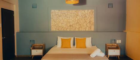 Quarto moderno com uma cama grande, duas mesas de cabeceira, uma obra de arte na parede e um lustre.