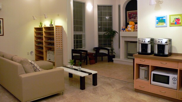 Uma sala de estar com sofá, mesa de centro, estante, lareira e micro-ondas.