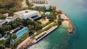 Resort com piscina, praia e vista para o oceano.