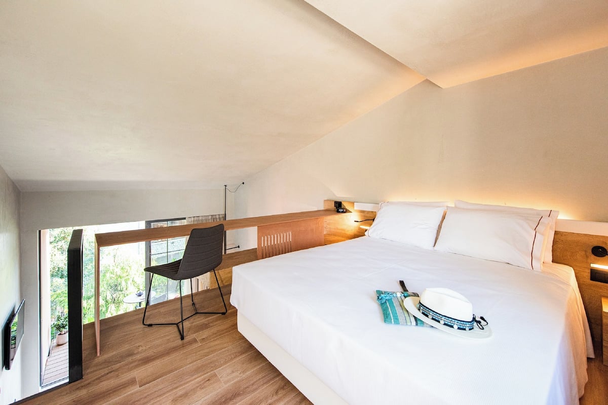 Quarto moderno com uma cama grande, uma escrivaninha e uma cadeira.