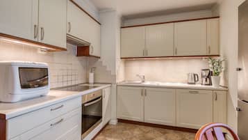 Apartamento conforto, 1 quarto | Cozinha privada | Geladeira, micro-ondas, fogão, cooktop