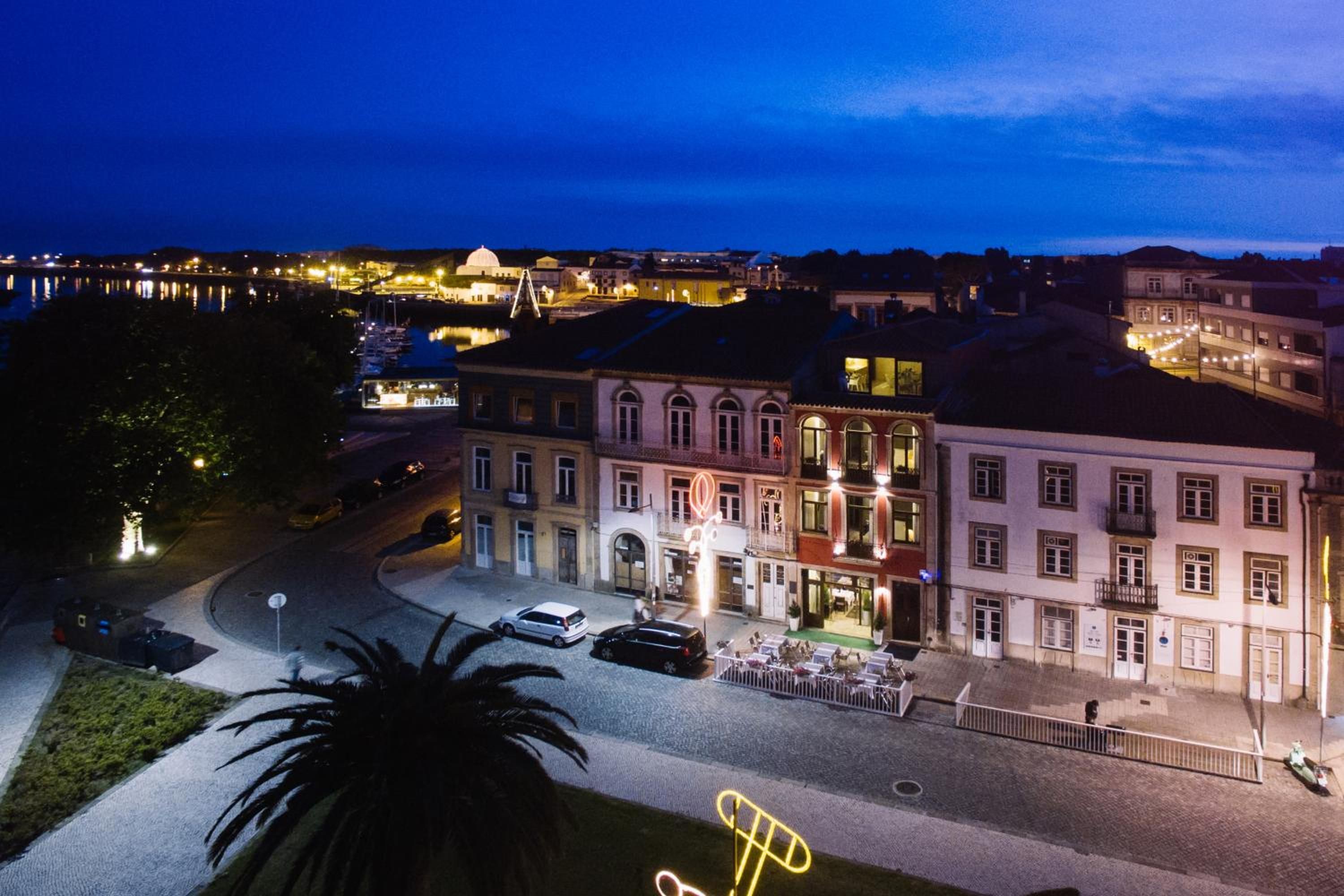 Hotel à beira-mar com edifício de destaque, varanda ampla e área de refeições com mesas ao ar livre.