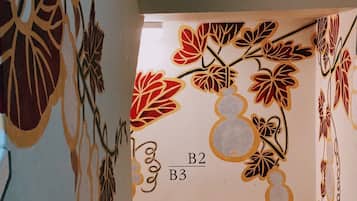 Parede com padrão decorativo de folhas estilizadas e um boneco de neve.