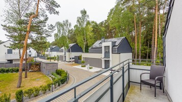 Uma área residencial moderna com casas, um caminho pavimentado e um pequeno jardim.