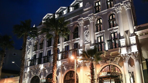 Um hotel imponente com arquitetura requintada, grandes entradas em arco e fachada bem iluminada.
