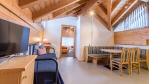 Um quarto acolhedor com cama, escrivaninha, banco e mesa.