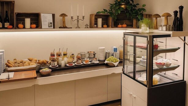 Disposição de buffet com diversos alimentos e uma vitrine de vidro.