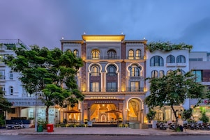 Um edifício histórico com uma entrada imponente, grandes janelas e uma placa com o nome