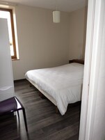 Quarto com cama, escrivaninha e janela.