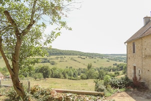 Um edifício de pedra com vista para um vale verde.