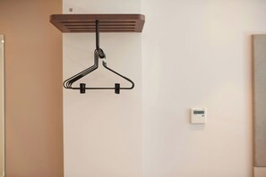 Um porta-toalhas fixado na parede com design simples, um termostato e uma parede lisa.