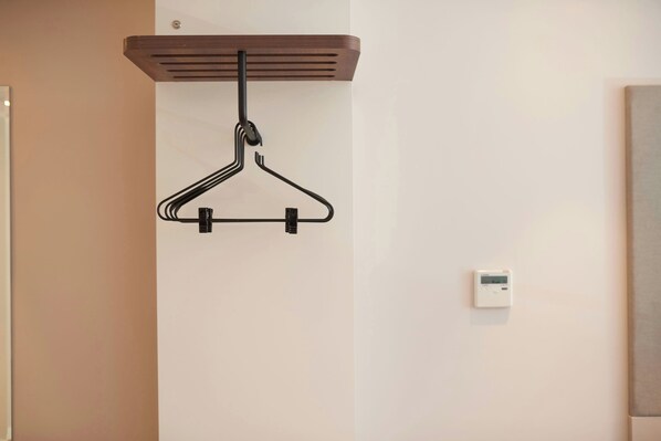 Um porta-toalhas fixado na parede com design simples, um termostato e uma parede lisa.