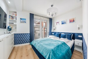 Quarto com cama, escrivaninha, globo e janela com persianas.