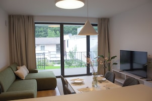 Uma sala de estar moderna com sofá, mesa de jantar e televisão.