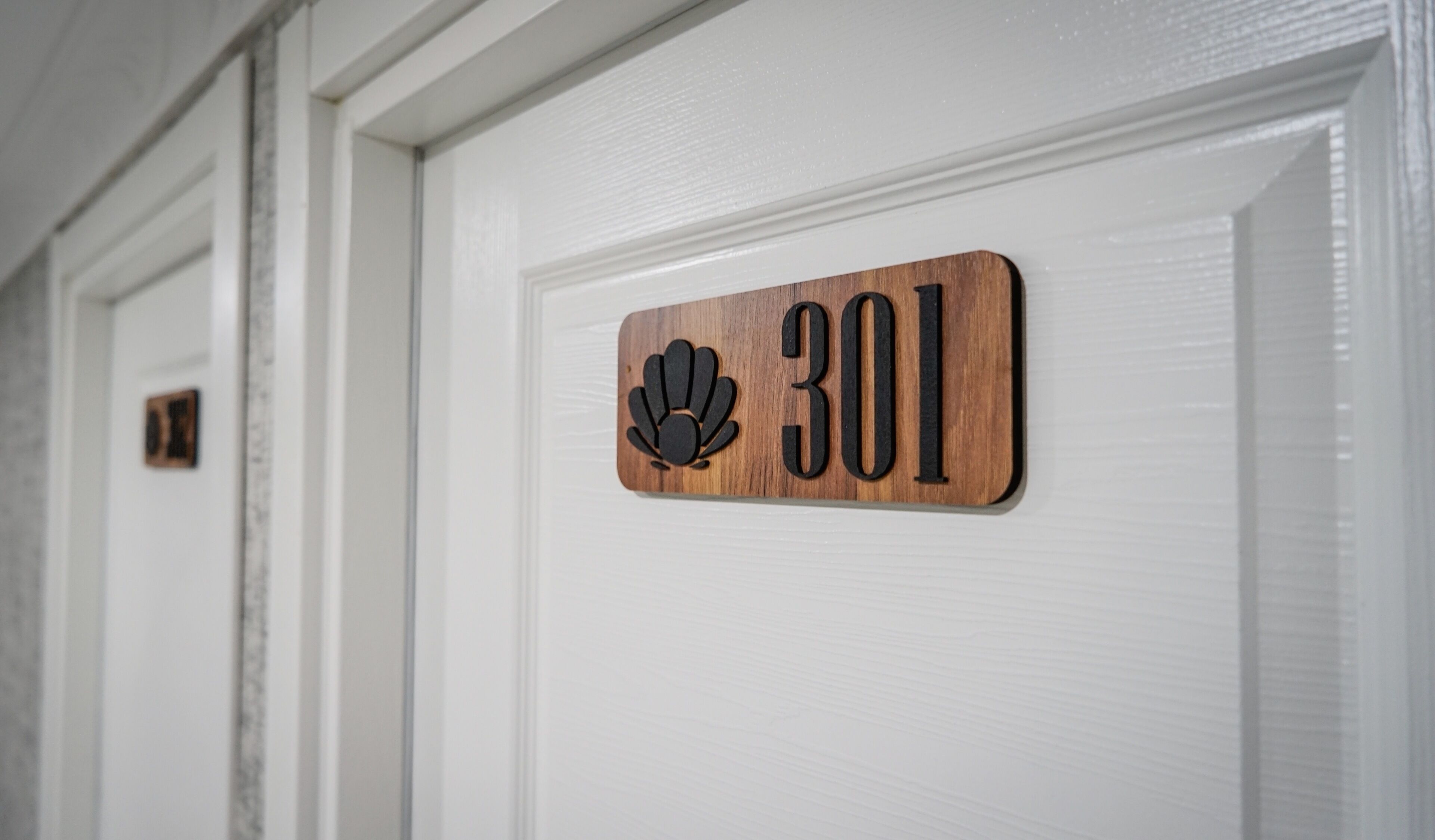 Uma porta de madeira com placa indicando o quarto 301.