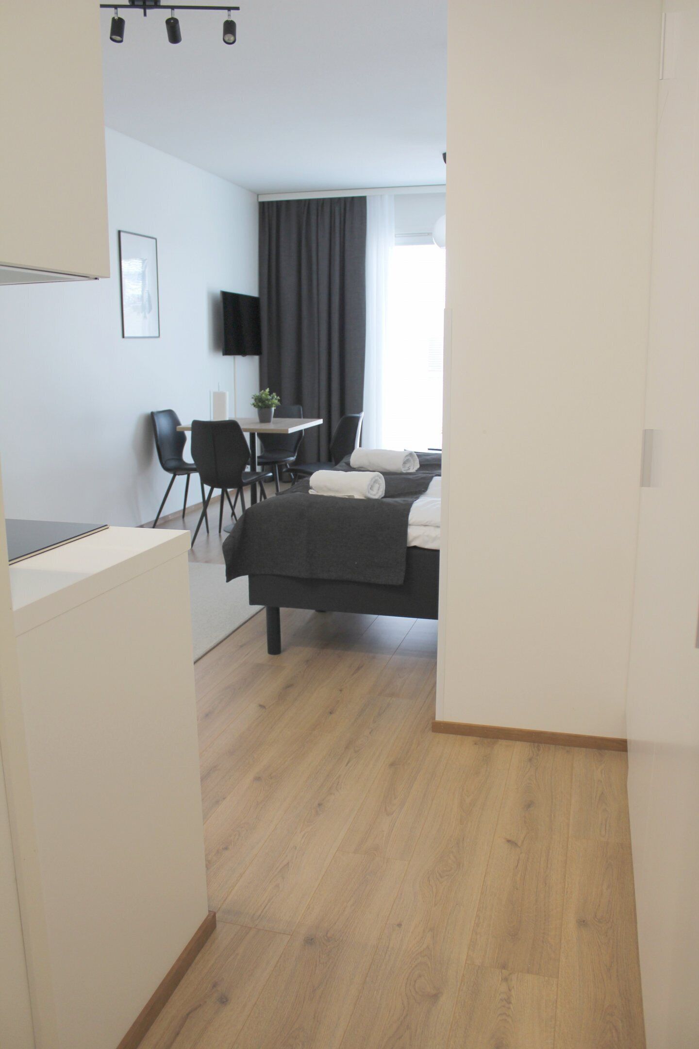 Quarto de hotel moderno com uma cama, uma escrivaninha e uma cadeira.