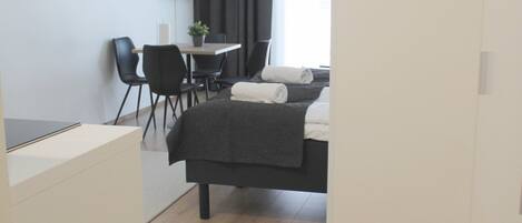 Quarto de hotel moderno com uma cama, uma escrivaninha e uma cadeira.