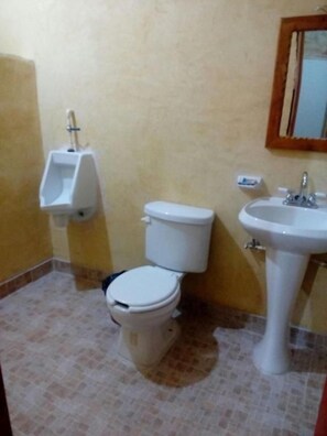 Casa de banho com sanita, lavatório e loiça sanitária.