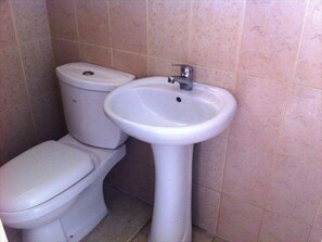 Casa de banho com sanita e lavatório assentado.